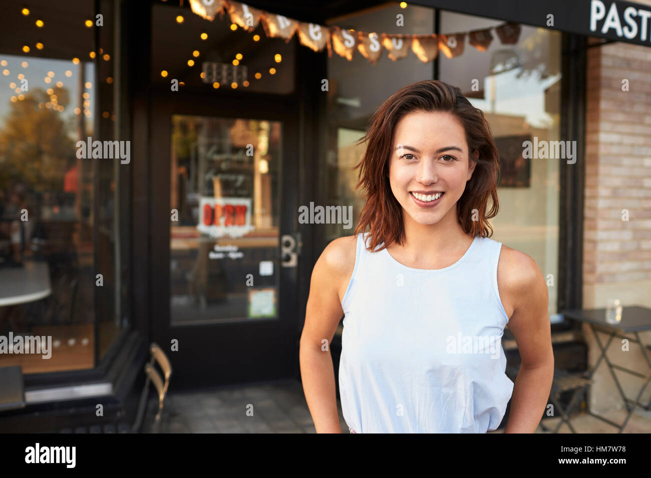 Female business owner standing in the street outside cafe Stock Photo ...
