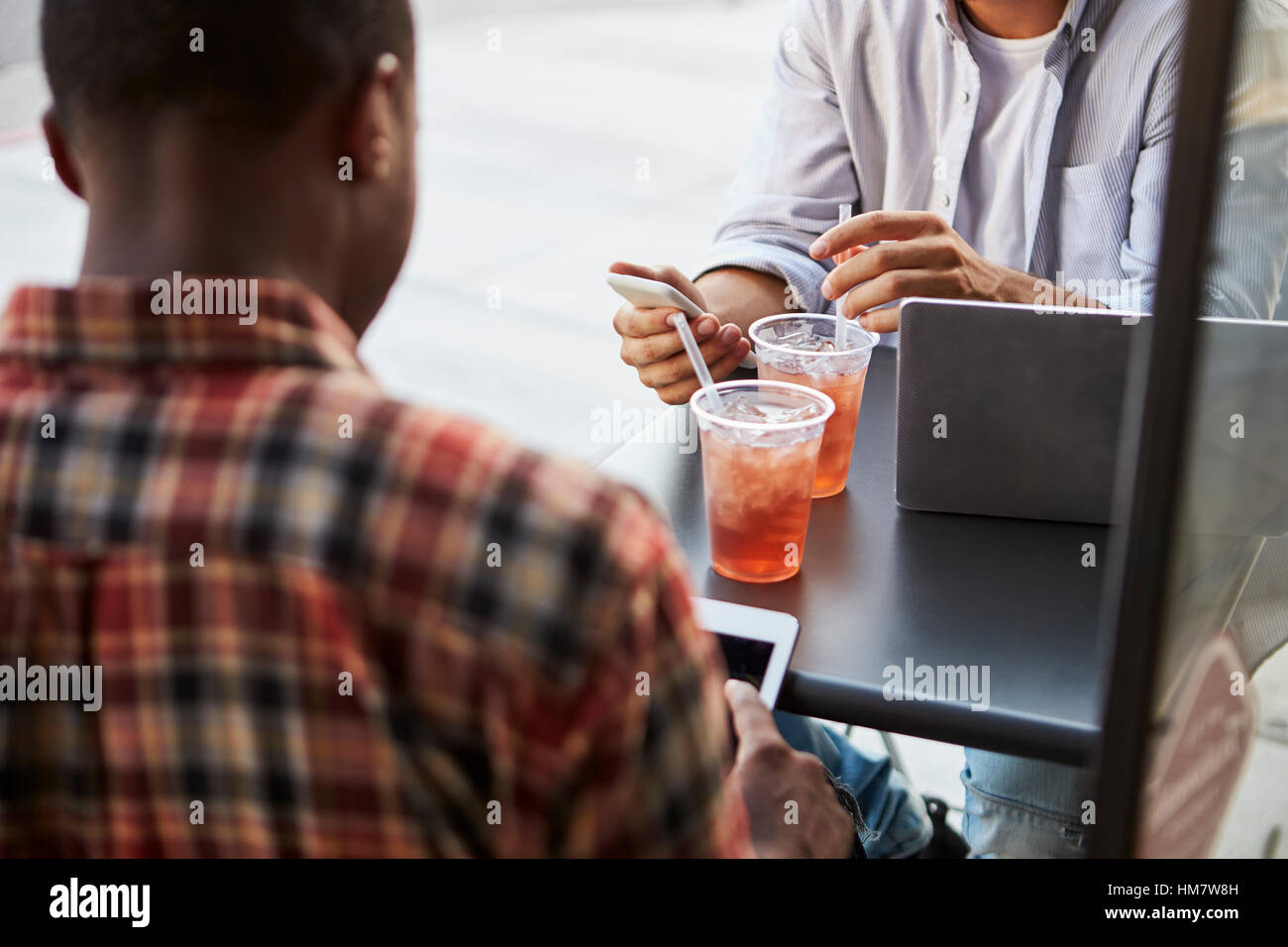 Crop shot of two male friends with cold drinks outside cafe Stock Photo ...