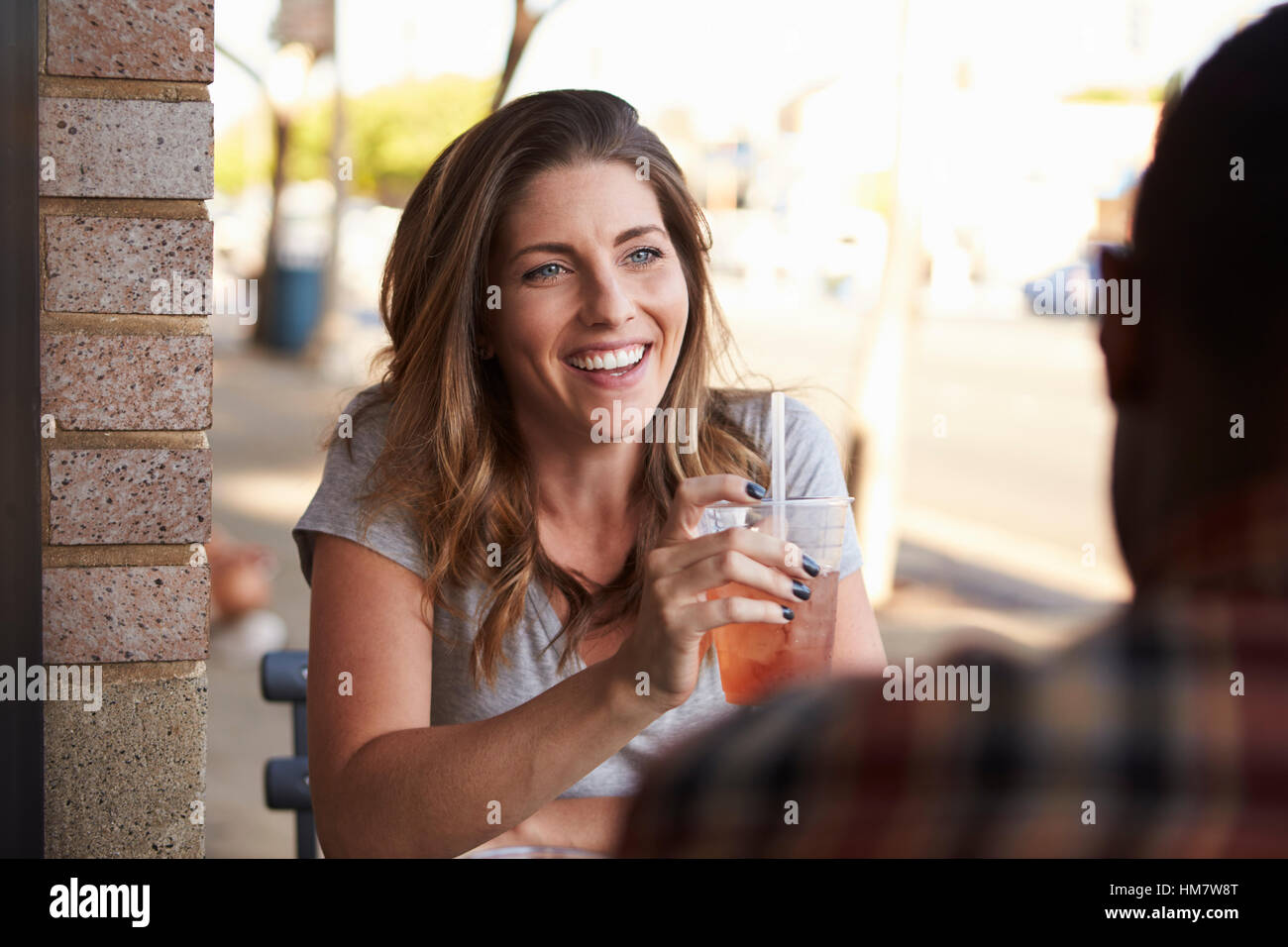 Couple relaxing with cold drinks at a table outside a cafe Stock Photo ...