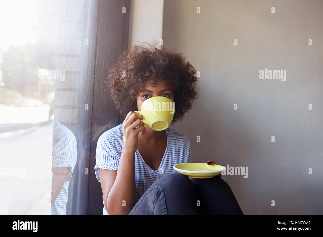 Woman sitting by a window hi-res stock photography and images - Alamy