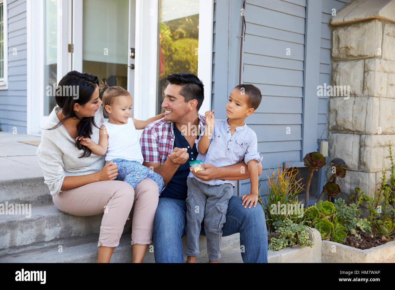 Father Giving Children Candy On Steps Outside Hose Stock Photo - Alamy