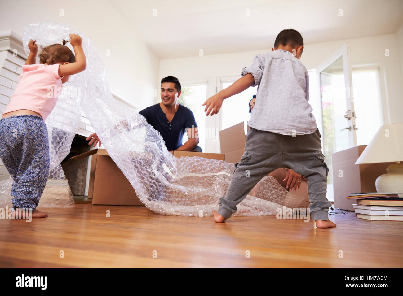 Family Unpacking Boxes In New Home On Moving Day Stock Photo - Alamy