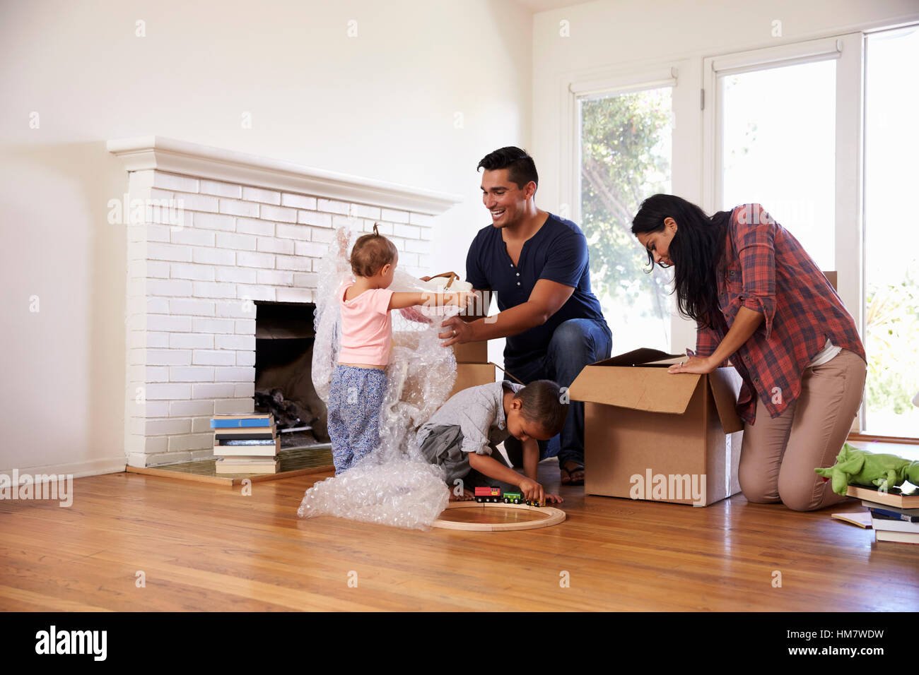 Family Unpacking Boxes In New Home On Moving Day Stock Photo - Alamy
