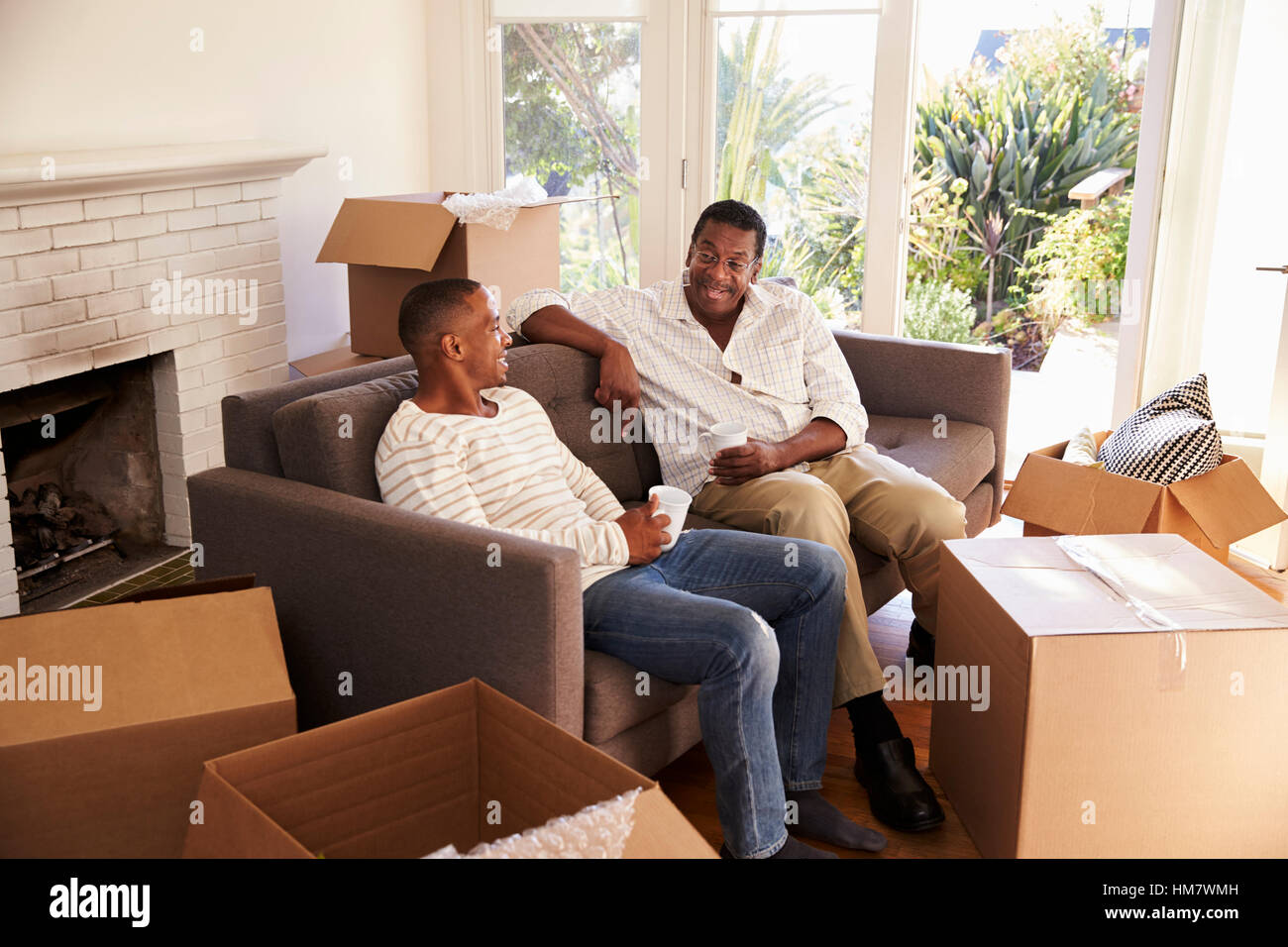 Father And Adult Son Take A Break With Pizza On Moving Day Stock Photo ...