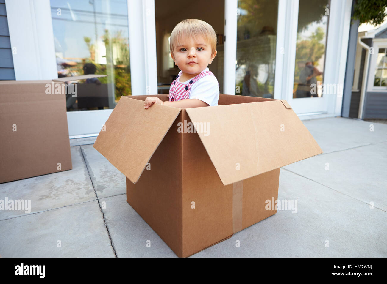 Little Boy Playing Inside Moving In Box Stock Photo - Alamy