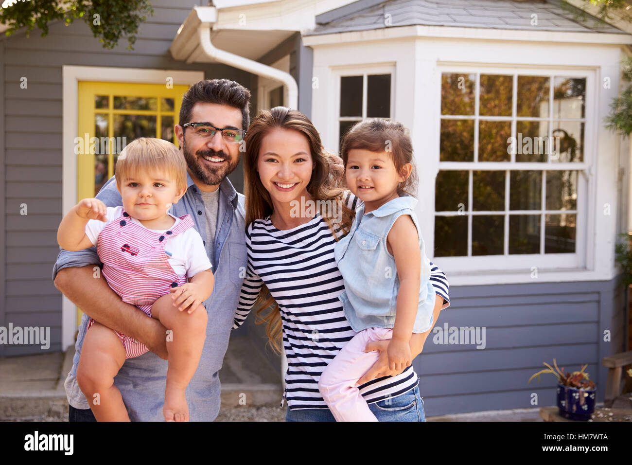 Portrait Of Excited Family Standing Outside New Home Stock Photo - Alamy