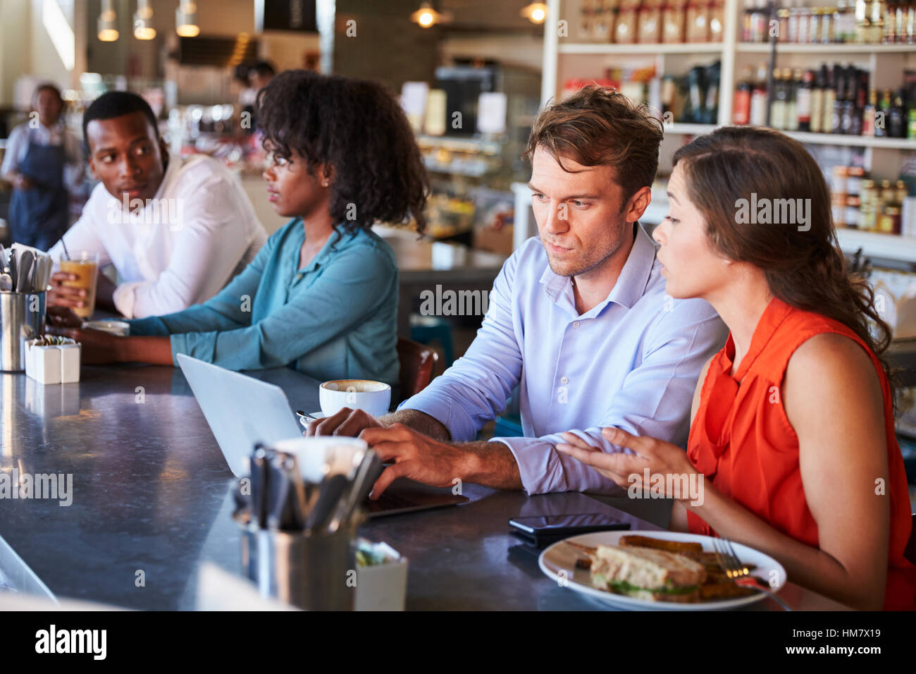 Group Enjoying Business Lunch At Delicatessen Counter Stock Photo - Alamy