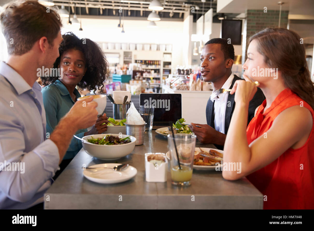 Group Enjoying Business Lunch In Delicatessen Stock Photo - Alamy