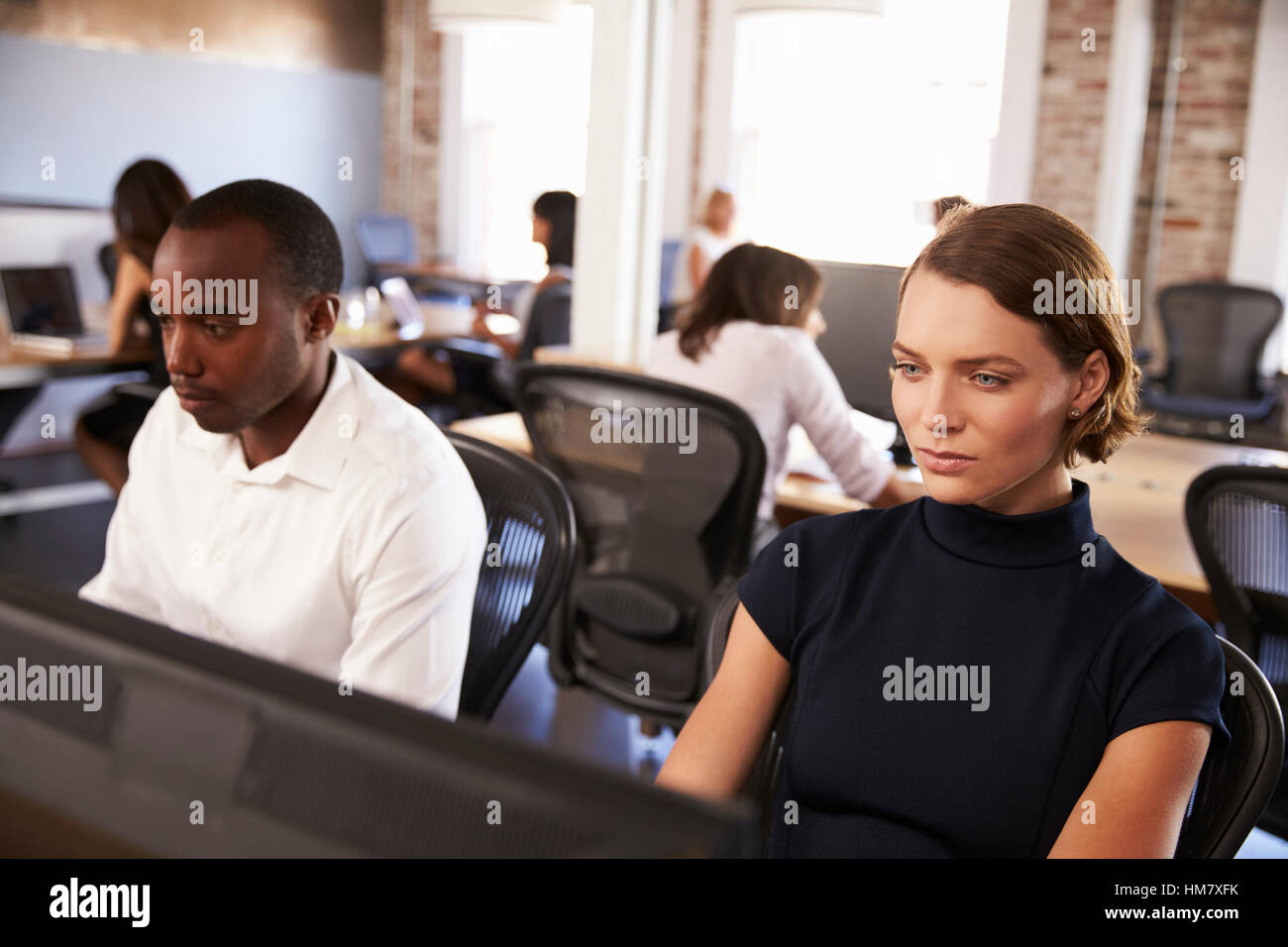 Businesspeople Working At Computers In Busy Modern Office Stock Photo ...