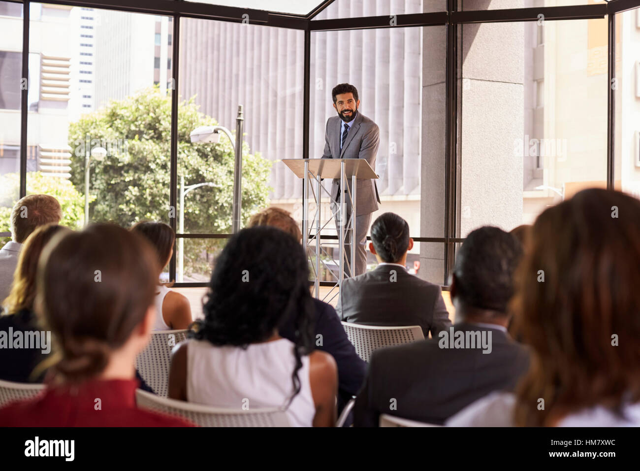 Hispanic man presenting business seminar leaning on lectern Stock Photo ...