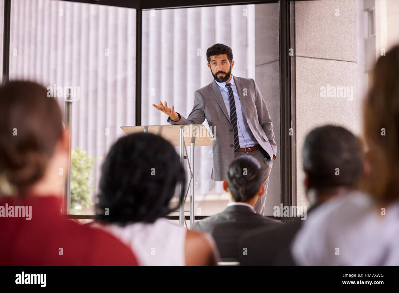 Hispanic man presenting business seminar leaning on lectern Stock Photo ...