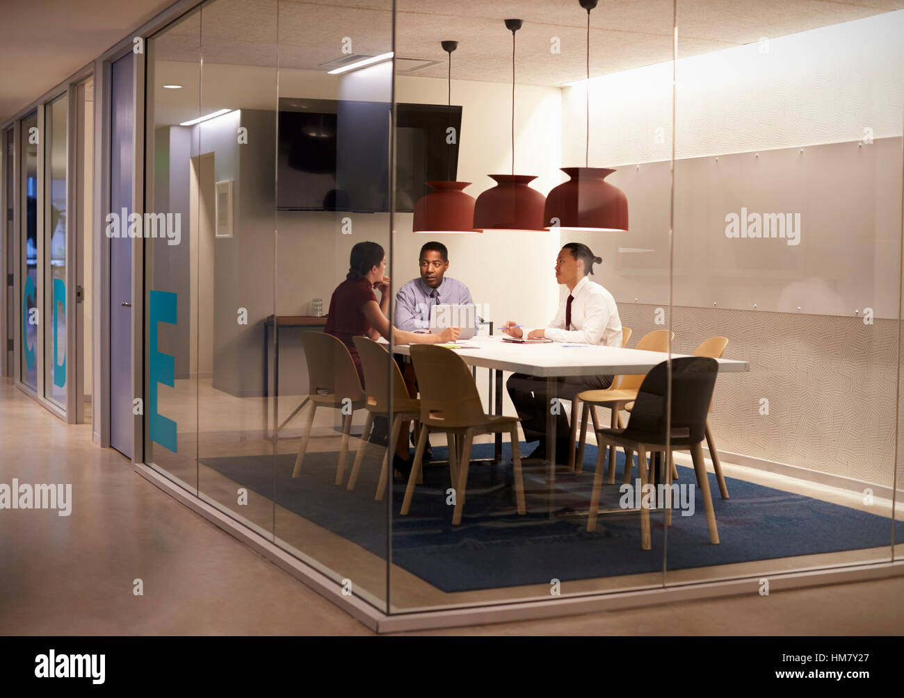 Three people in meeting cubicle at a big corporate business Stock Photo ...
