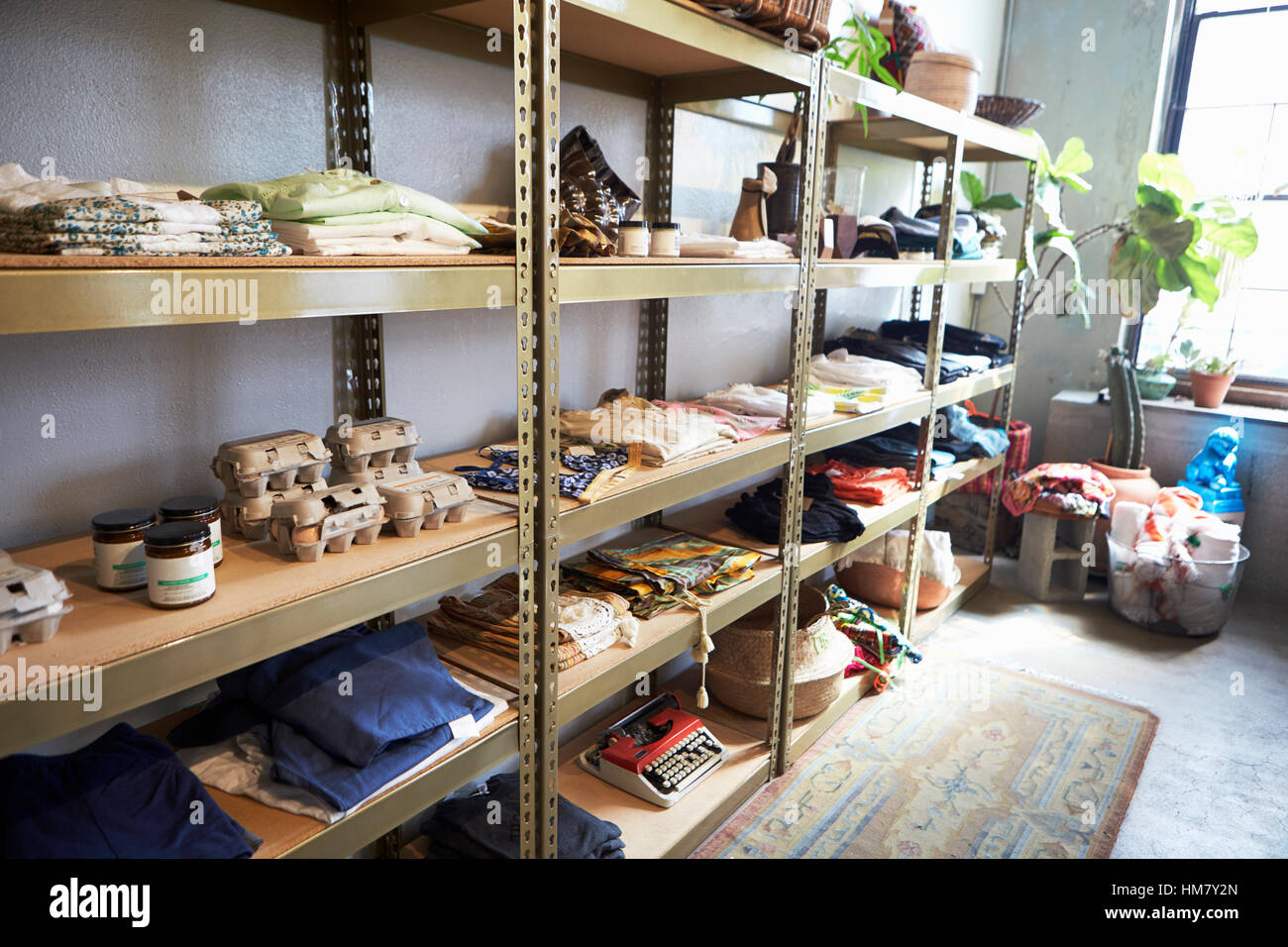 Clothes and ephemera displayed on shelves in a clothing shop Stock ...