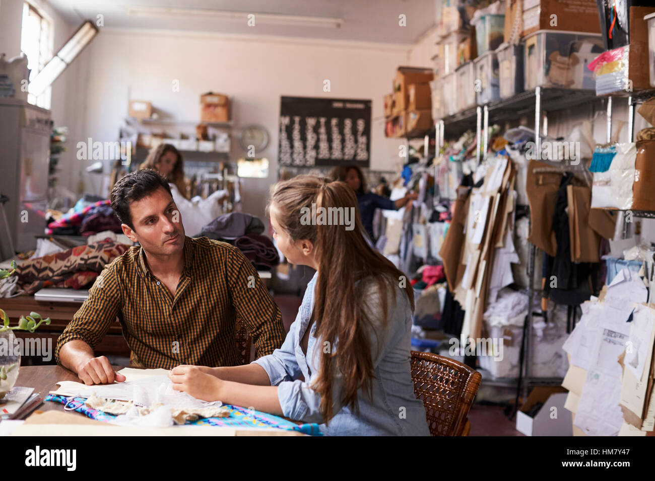 Male manager training apprentice at a clothing design studio Stock ...