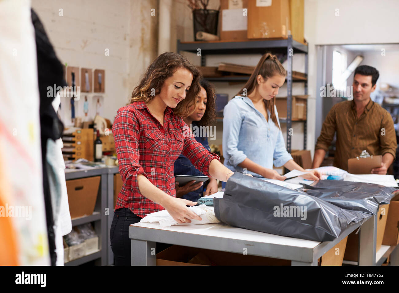 Team in a post room packing clothes orders for distribution Stock Photo ...