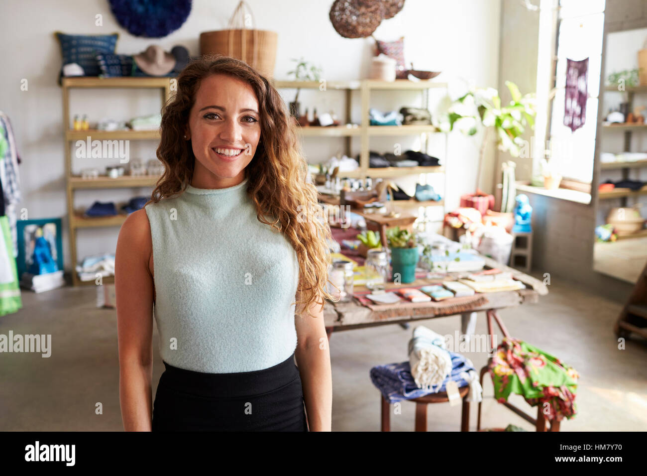Female sales assistant standing in clothes shop, portrait Stock Photo ...