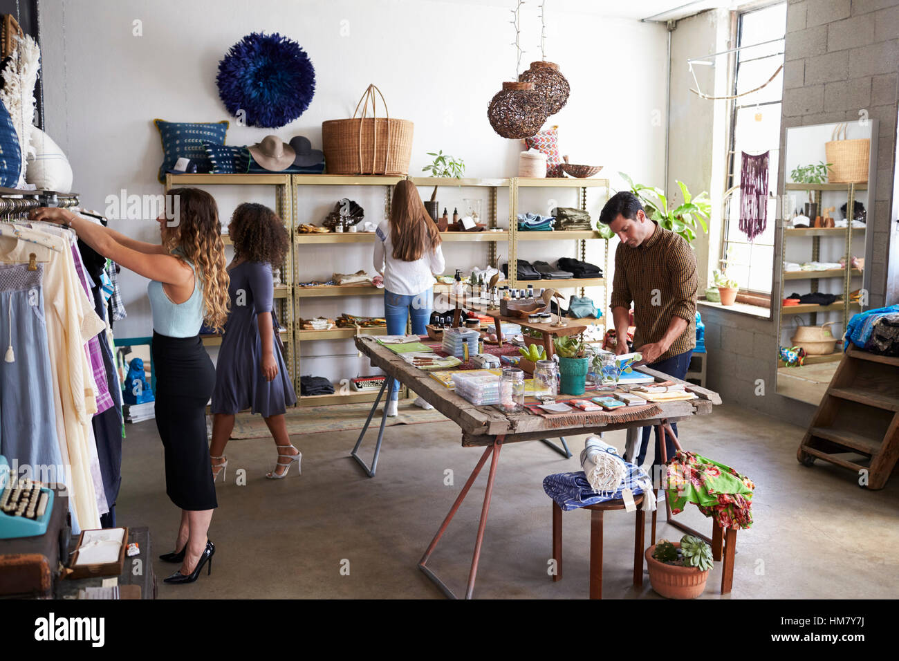 Customers and staff in a busy clothes shop Stock Photo - Alamy
