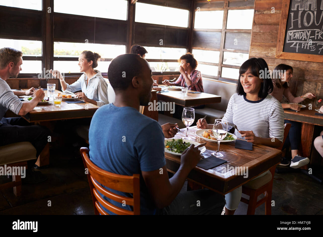 Mixed race couple enjoying lunch in a busy restaurant Stock Photo - Alamy