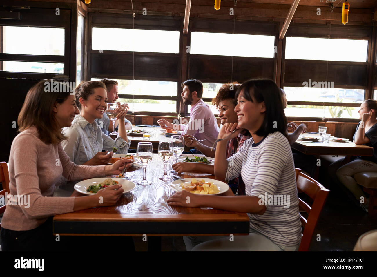 Four female friends at a girls’ lunch in a busy restaurant Stock Photo ...