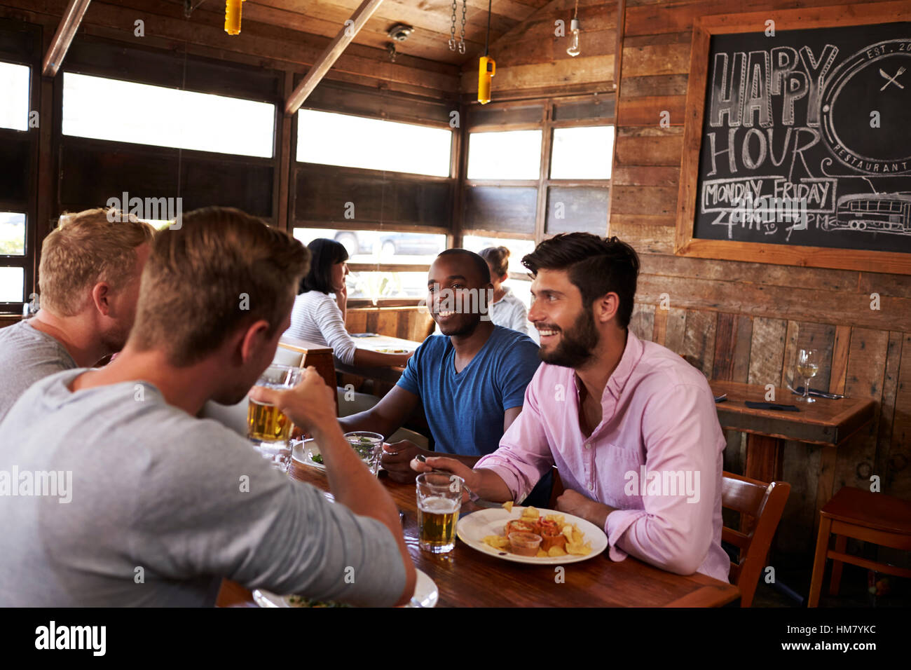 Four male friends at lunch together in restaurant, close up Stock Photo ...