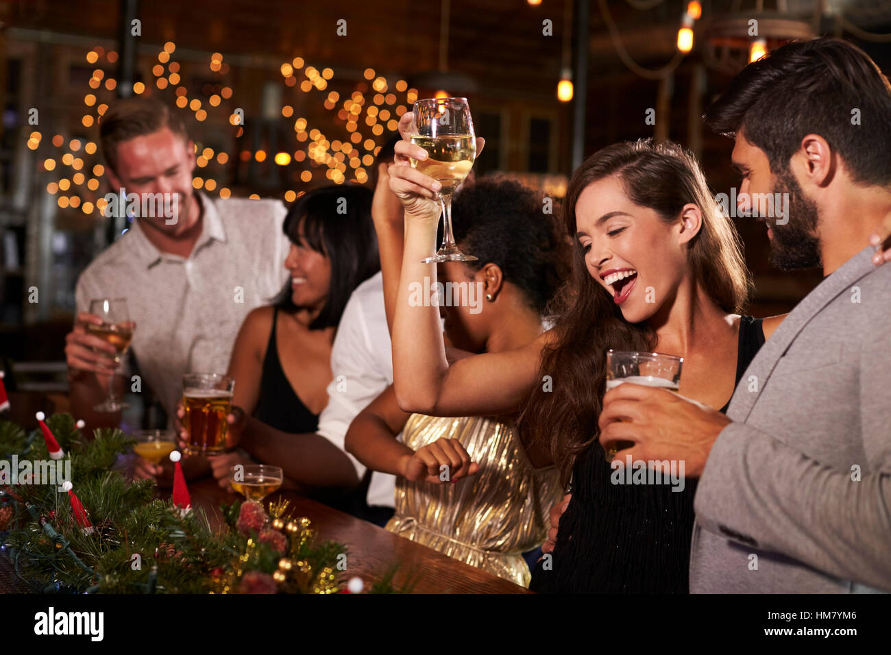 Woman raising a glass at a Christmas party in a bar Stock Photo - Alamy