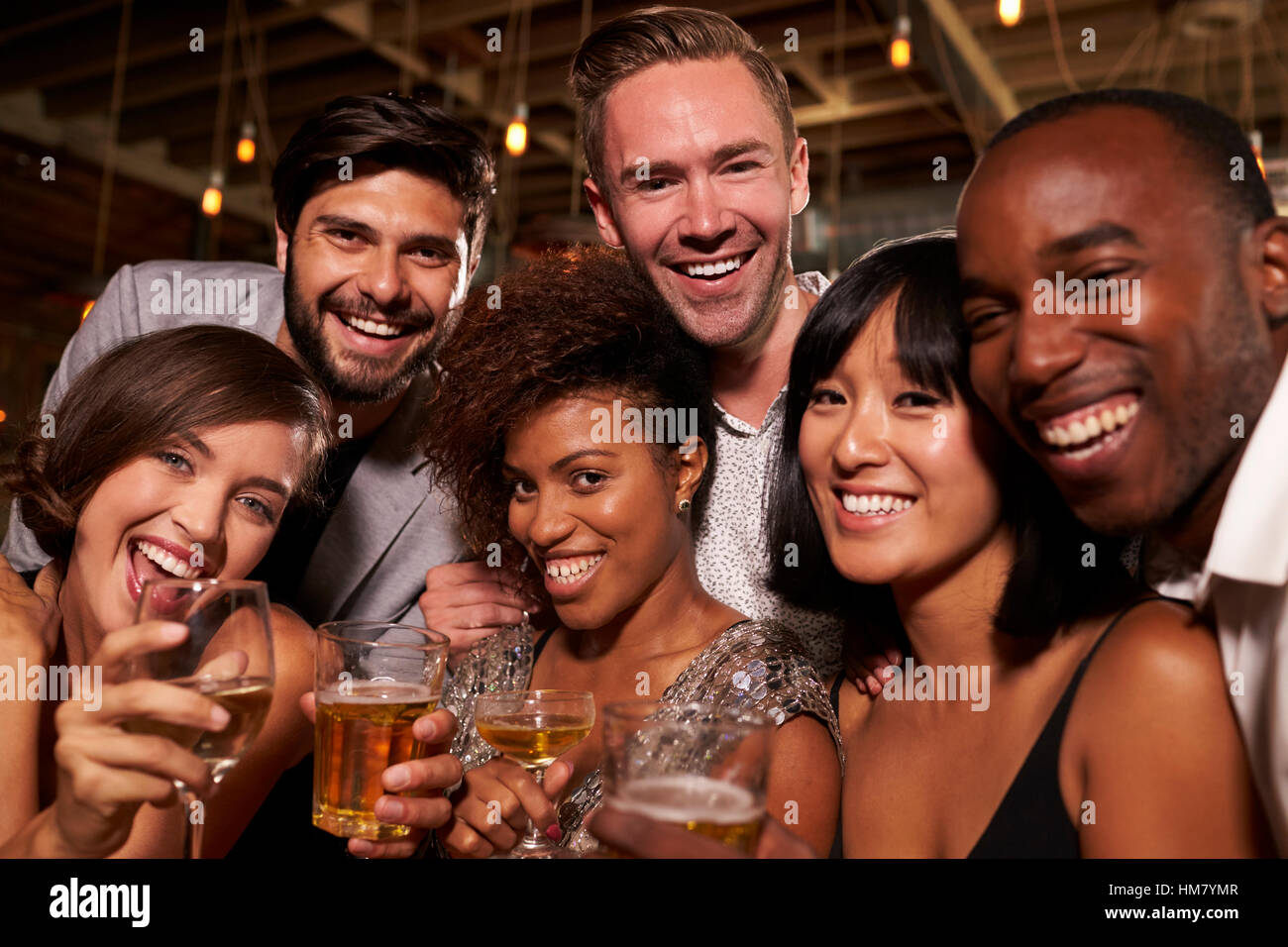 Happy friends at a party in a bar look to camera, close up Stock Photo ...