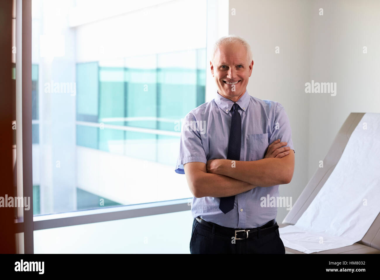 Portrait Of Male Doctor Standing In Exam Room Stock Photo - Alamy