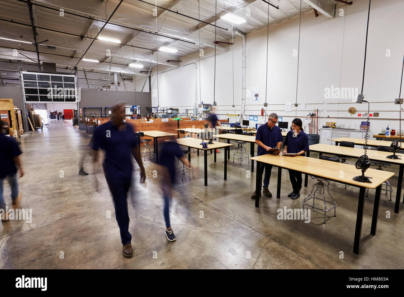 Interior Of Busy Factory With Staff At Work Benches Stock Photo - Alamy