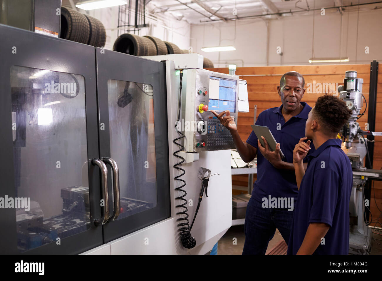 Engineer Training Young Male Apprentice On CNC Machine Stock Photo - Alamy
