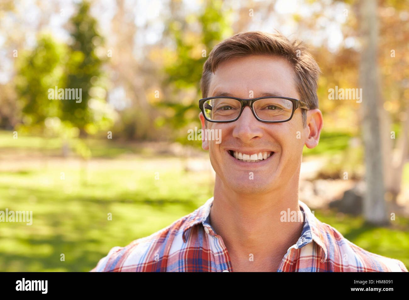 Middle aged white man in glasses smiling to camera in a park Stock ...