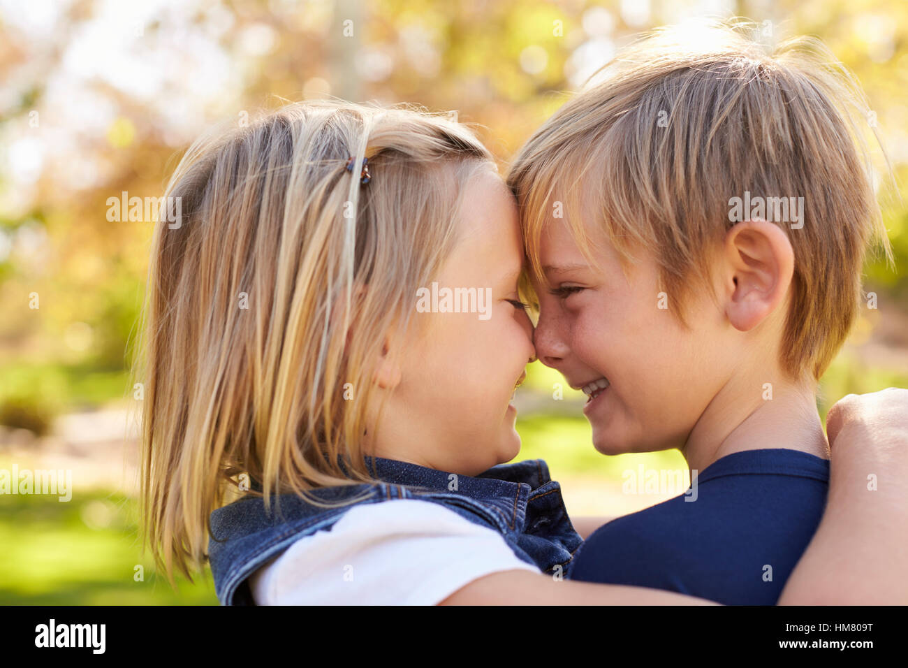 Young brother and sister nose to nose in a park, side view Stock Photo ...