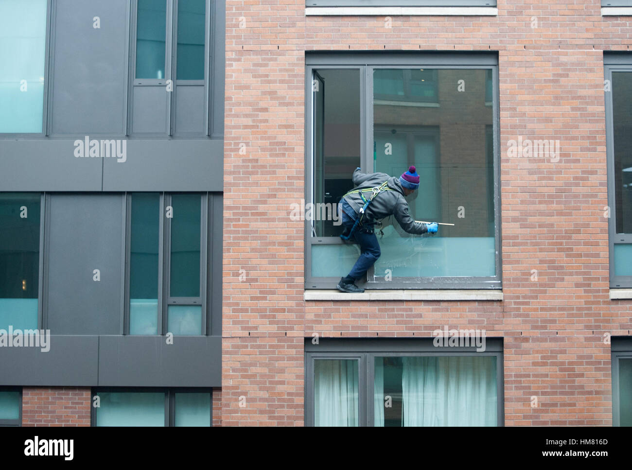 A man balanced himself as he washed windows in an apartment building in ...