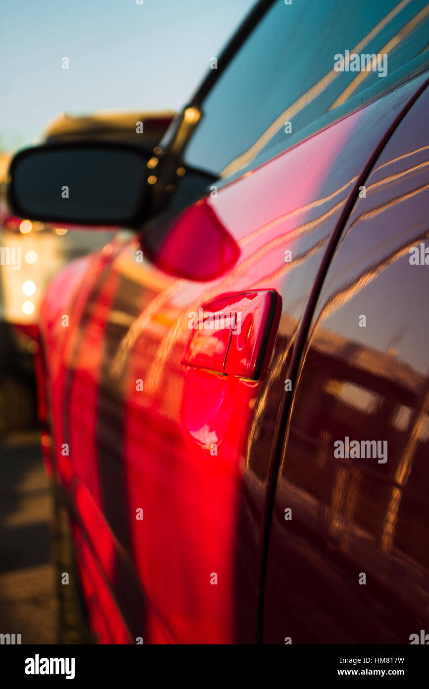 Shining handle of red car door with blurred background Stock Photo - Alamy
