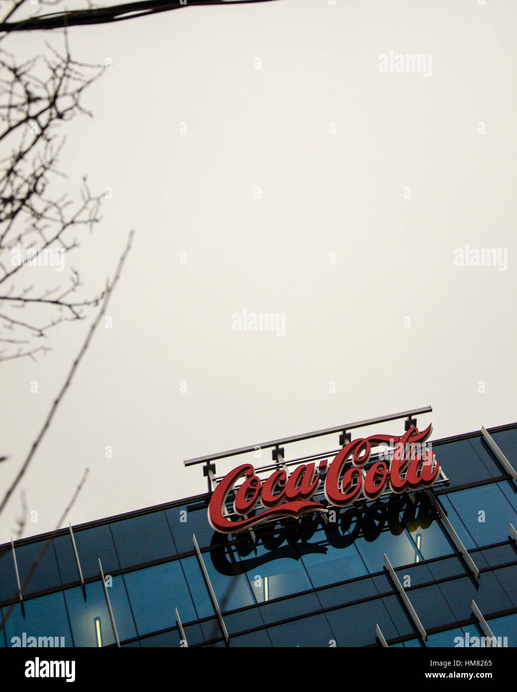 A picture of the colourful Coca Cola building with the cloudy sky ...
