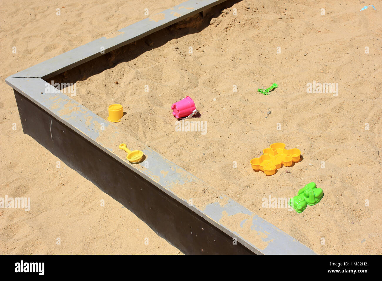 Children's sandbox with yellow sand and bright plastic toys Stock Photo ...