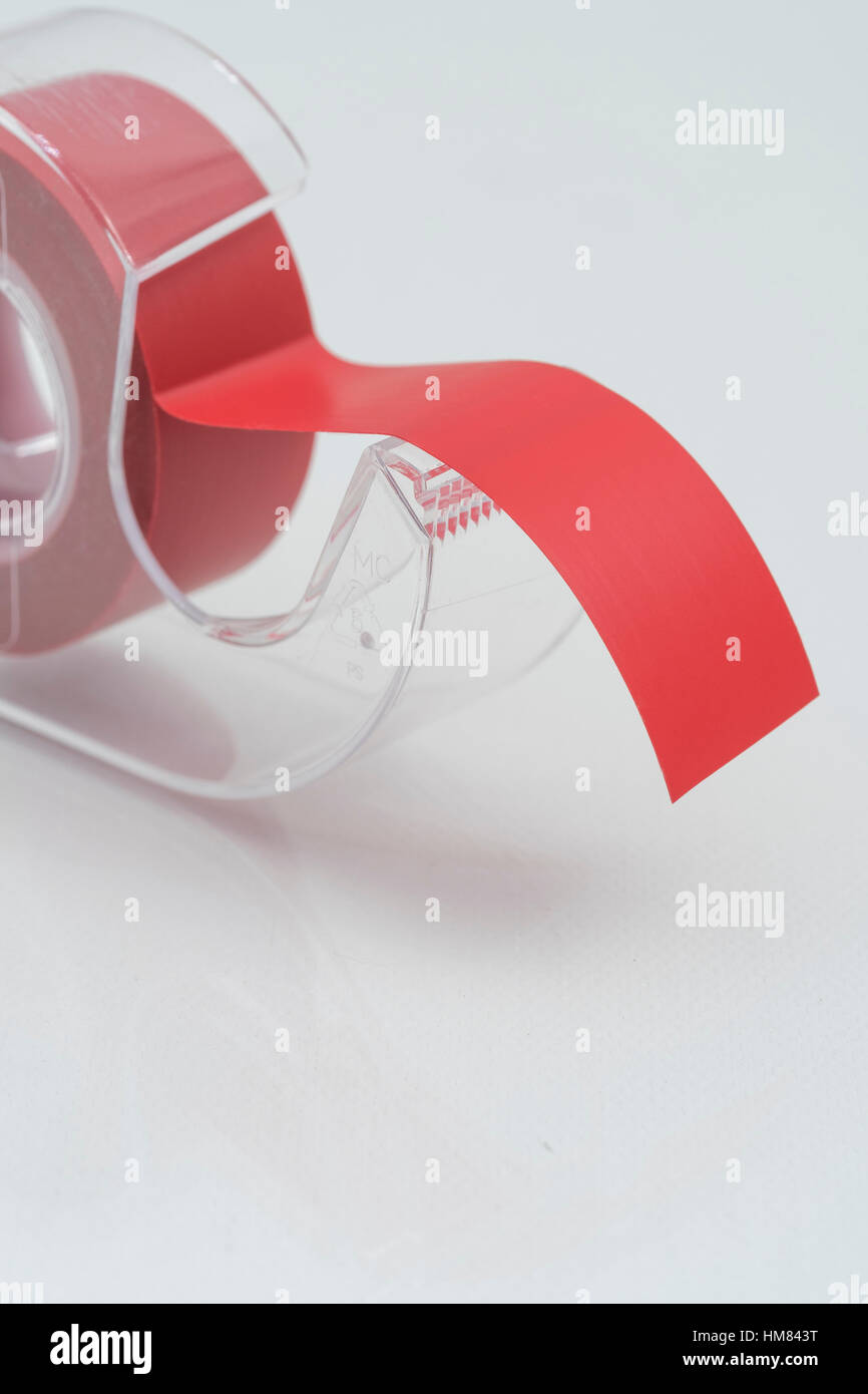 Roll or red tape in a sticky tape dispenser - as visual metaphor for ...