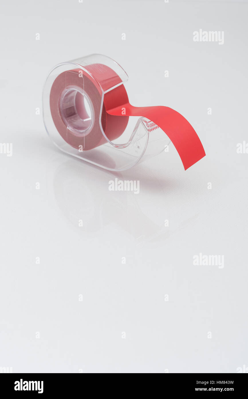 Roll or red tape in a sticky tape dispenser - as visual metaphor for ...