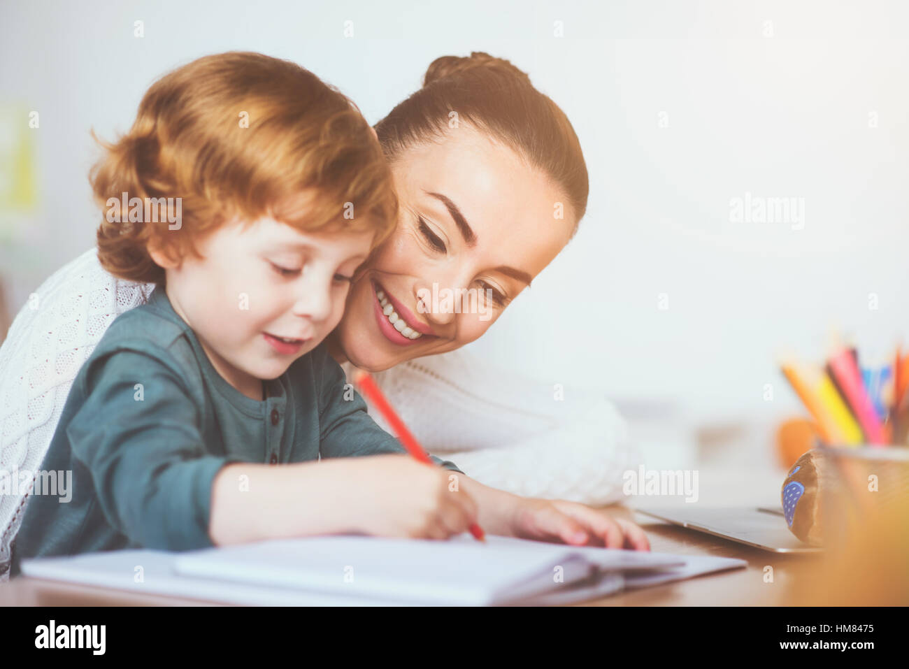 Smiling mother teaching her son to write Stock Photo - Alamy