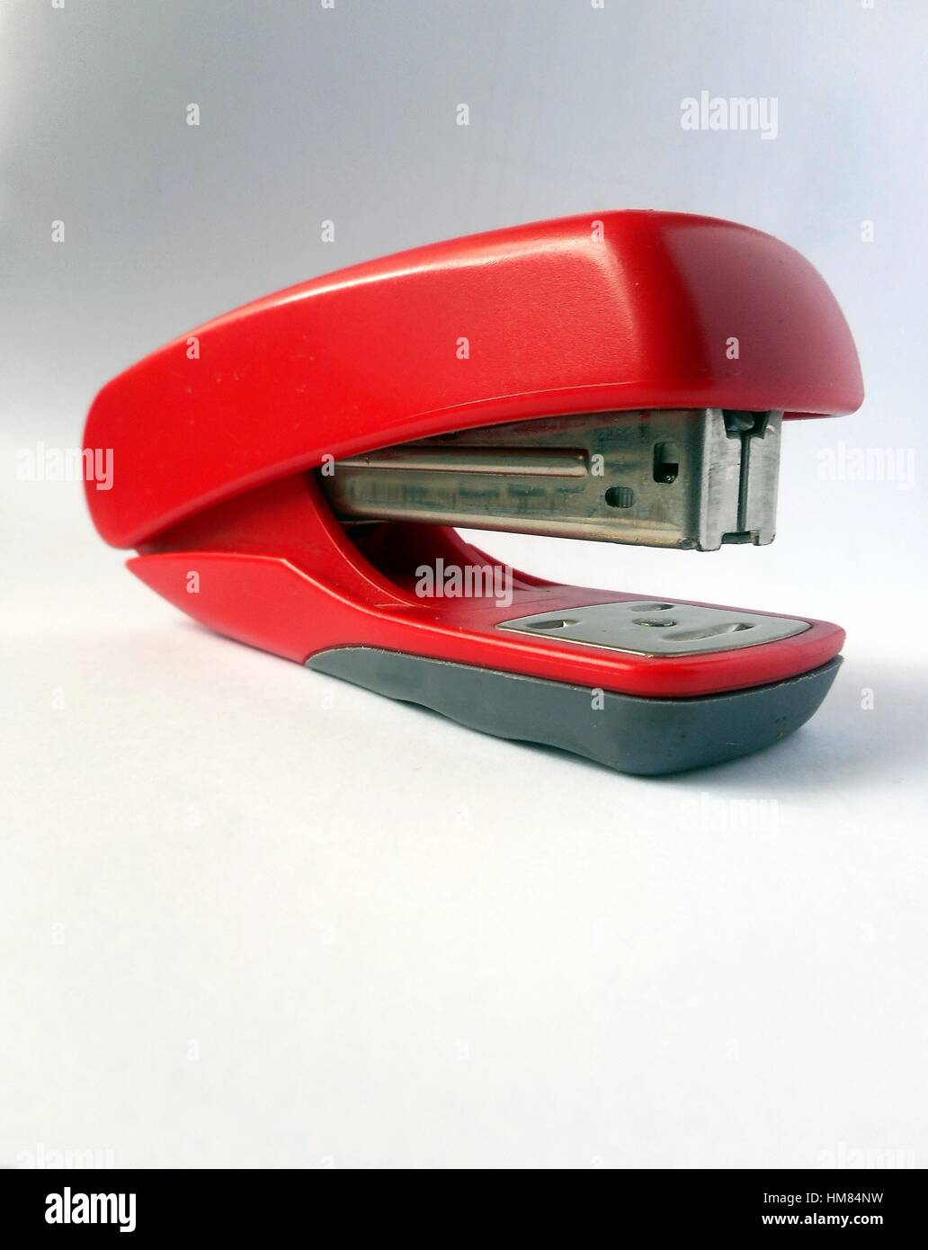 Red stapler against a white background Stock Photo - Alamy