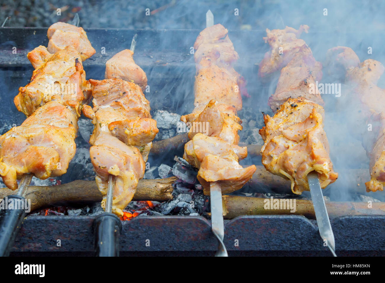 Grilled kebab cooking on metal skewer. Roasted meat cooked at barbecue ...