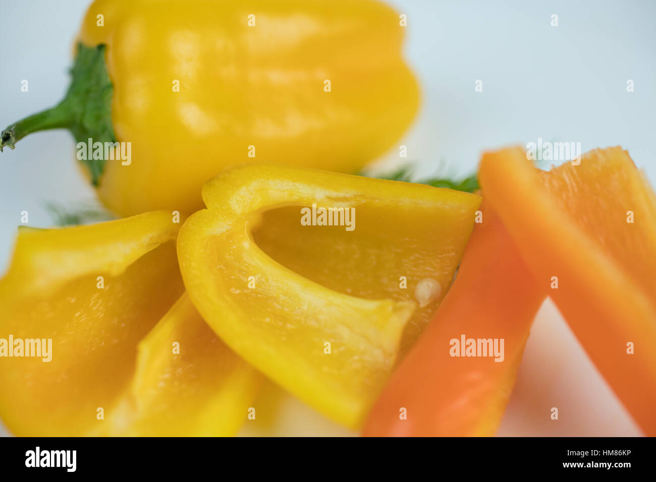 Yellow and orange mini peppers on a plate, sliced to be used as an ...