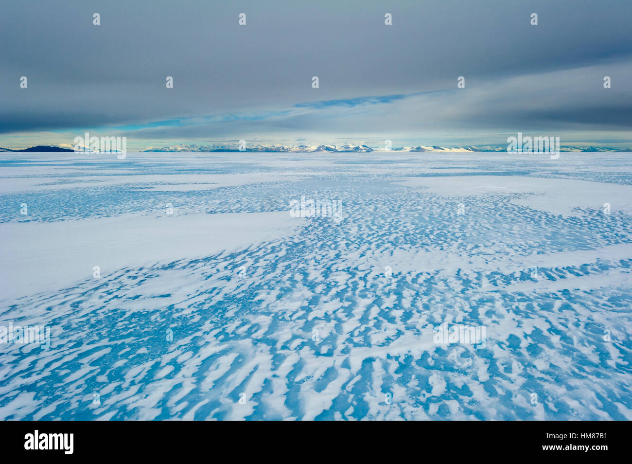 Wind patterns gather in snow drifts on the frozen sea ice in Antarctica ...