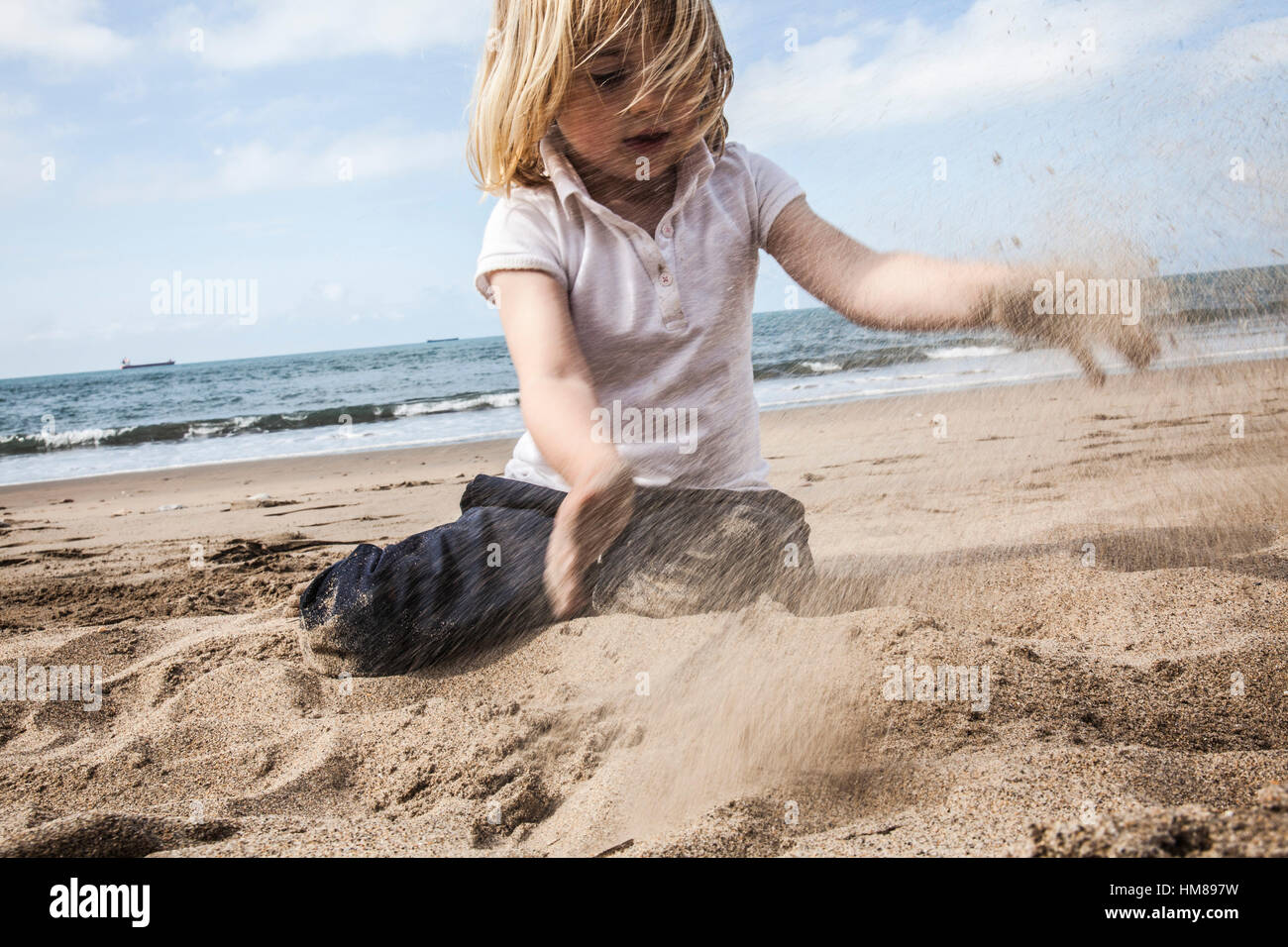 Boy on the beach playing with sand hi-res stock photography and images ...