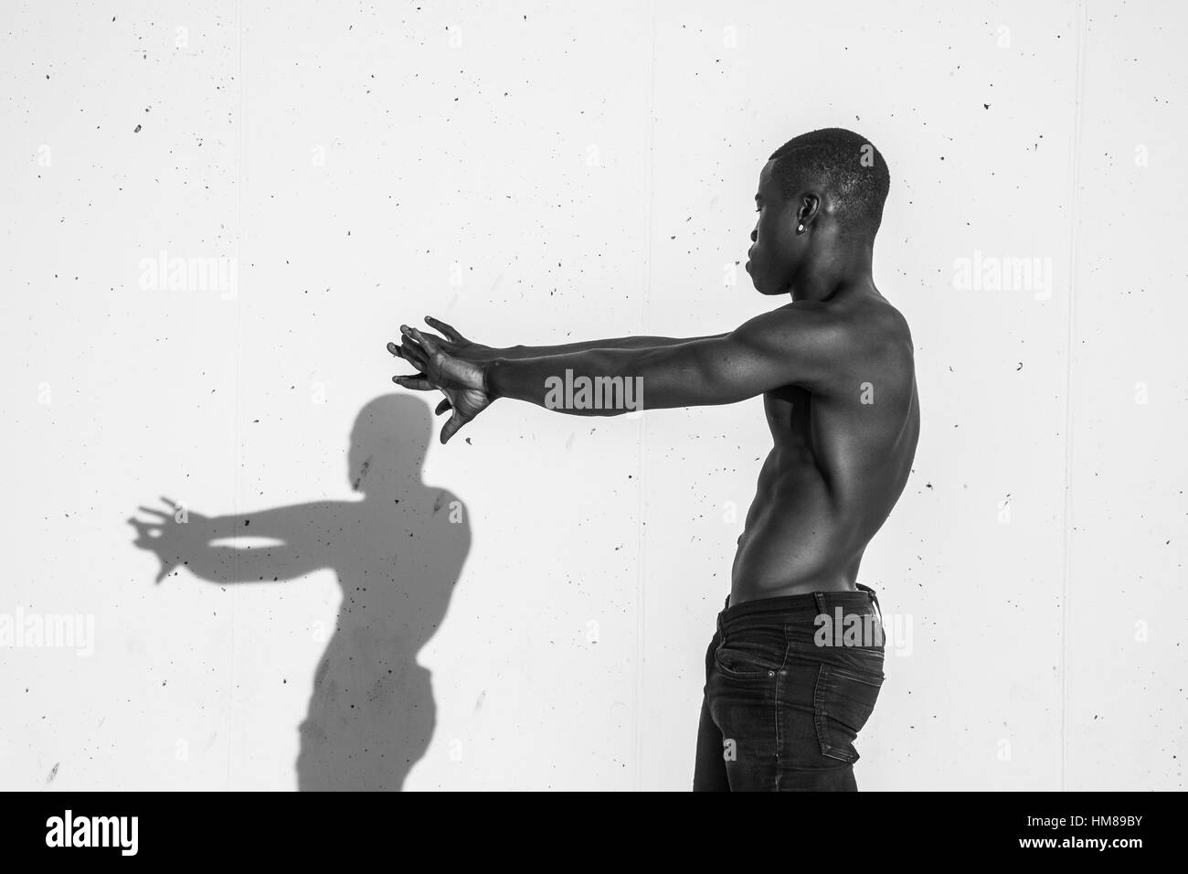 Portrait of Shirtless Young Adult Man Stretching Arms with Shadow Cast ...