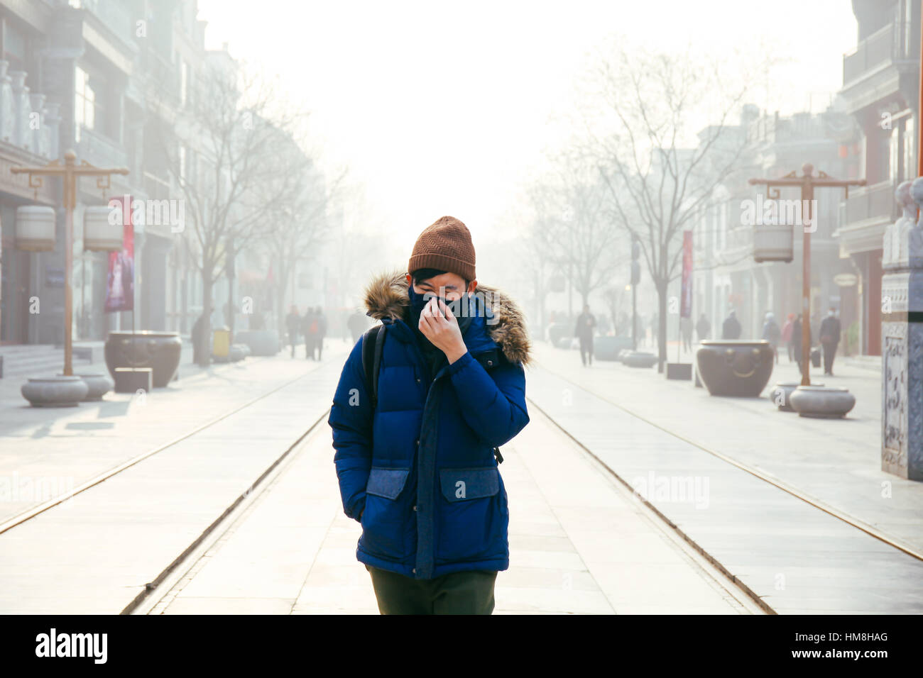 Asian man walking and wearing a face mask in a foggy smog and hazy day ...