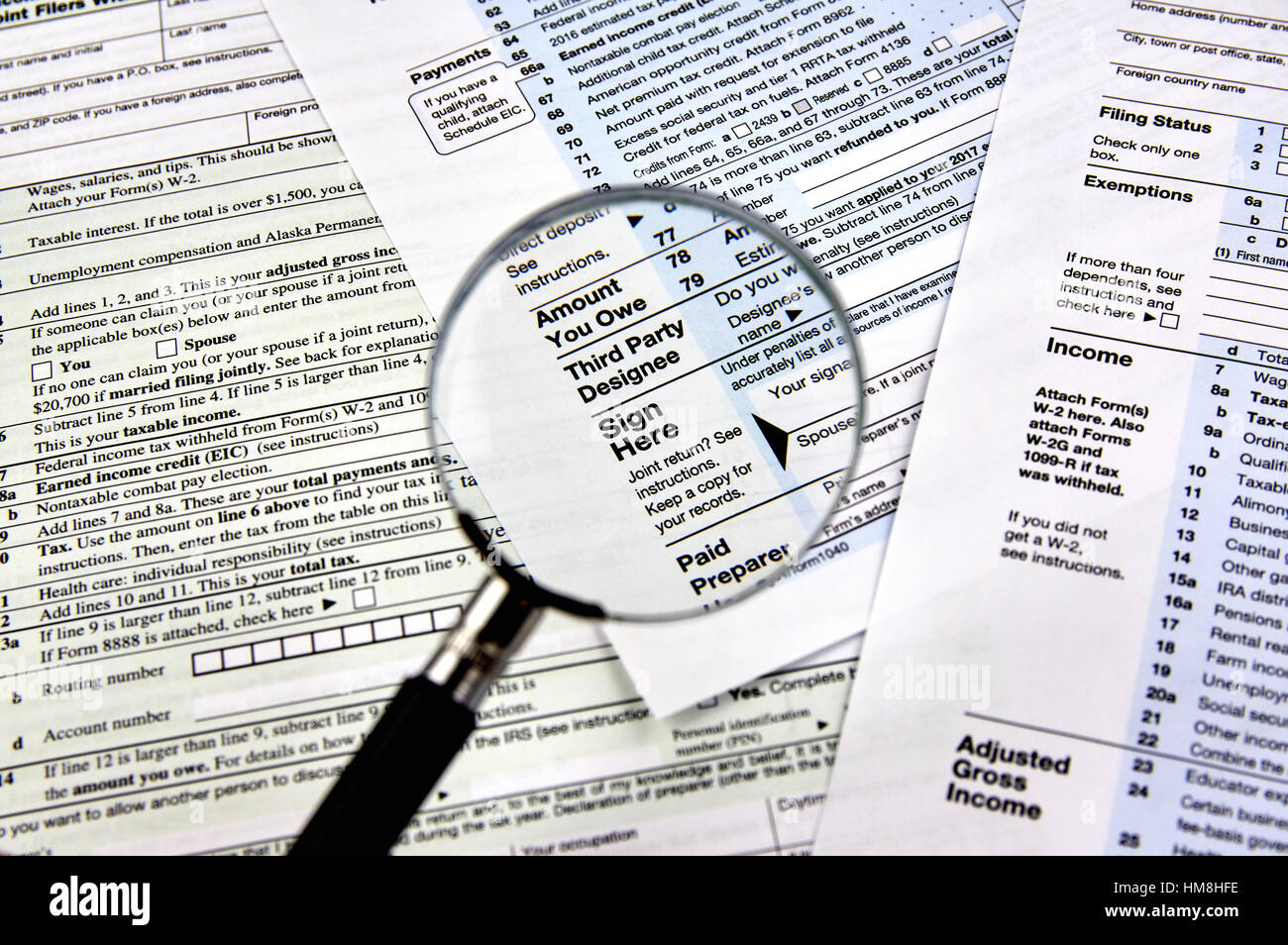 'Sign here' under magnifying glass on 1040 U.S individual income tax ...