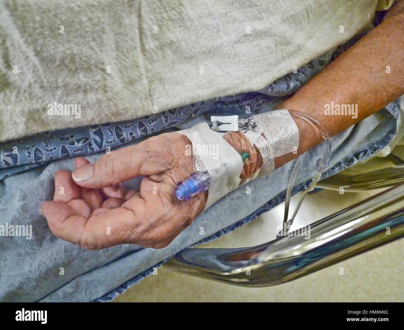 A patient receives an IV (Intravenous therapy) in a hospital prior to ...