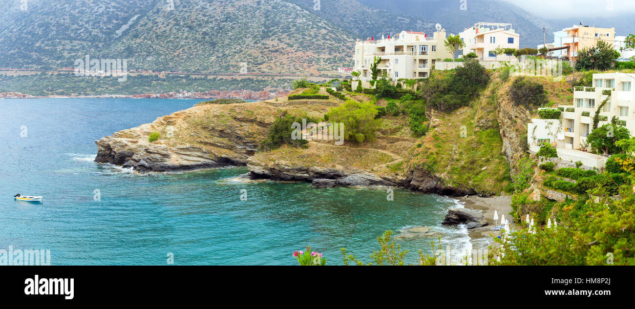 Empty motorboat drifting on waves near rocky shore. Sea view from cliff ...