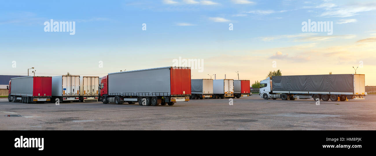 Heavy trucks loaded with goods trailers, parked in waiting area on ...