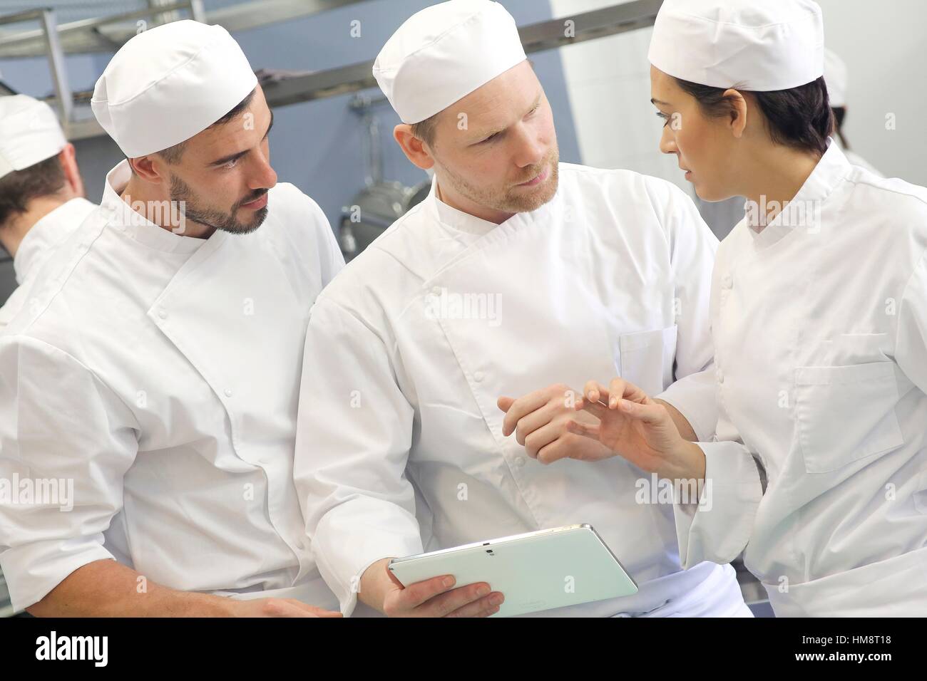 Restaurant kitchen workers talking Stock Photo - Alamy